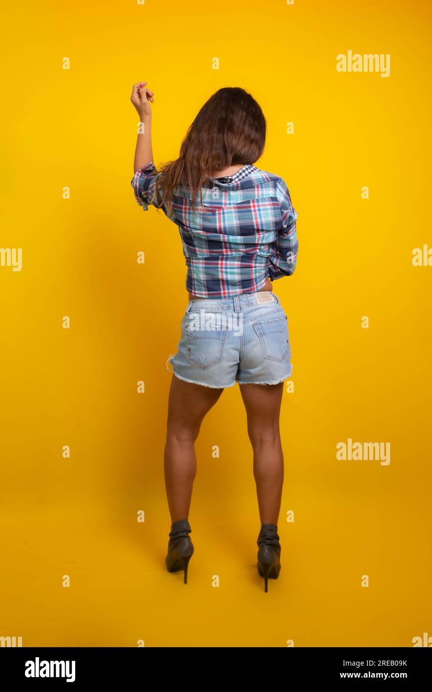 Beautiful mature woman standing with her back to the camera, dressed in ...