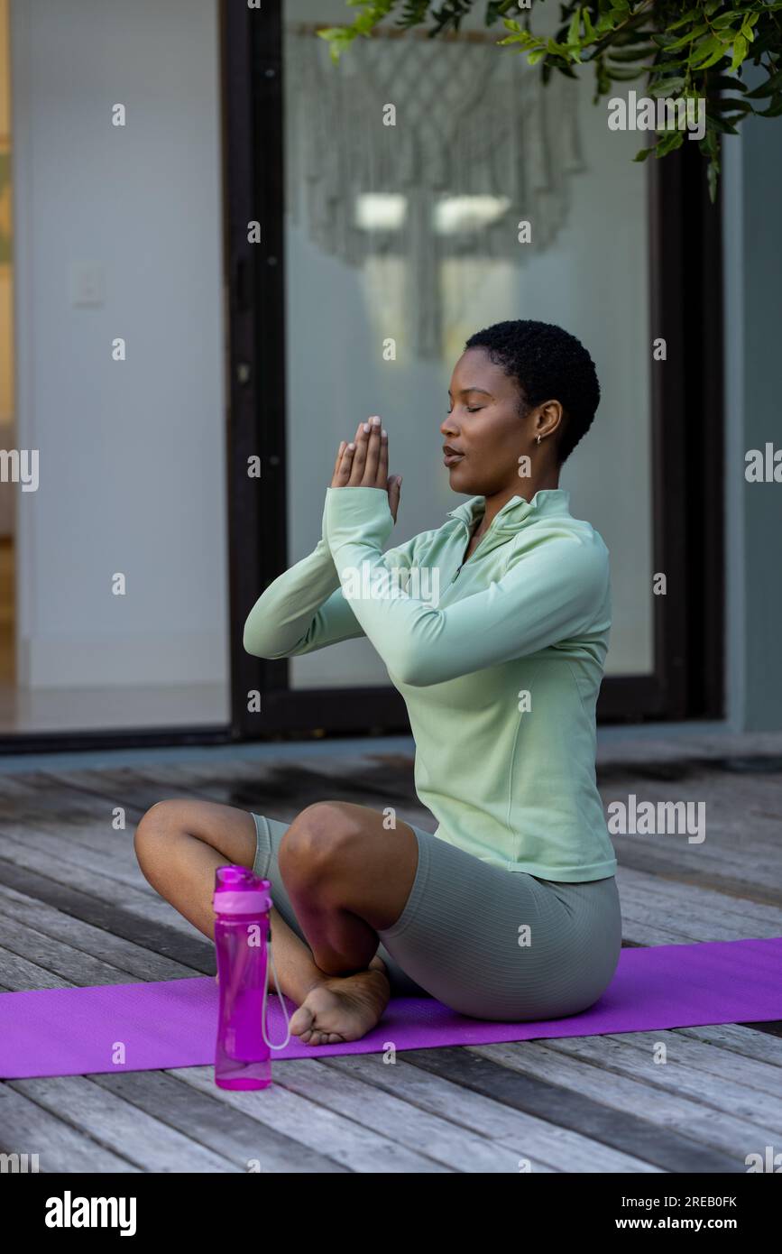 African american woman doing yoga, meditating on terrace Stock Photo ...