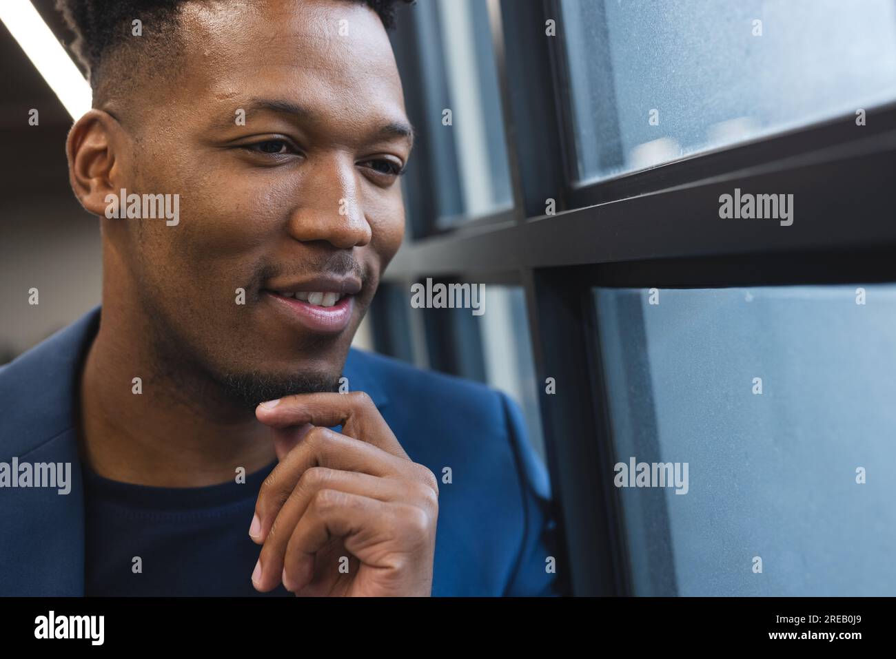 Happy african american man looking out of the window at office Stock ...