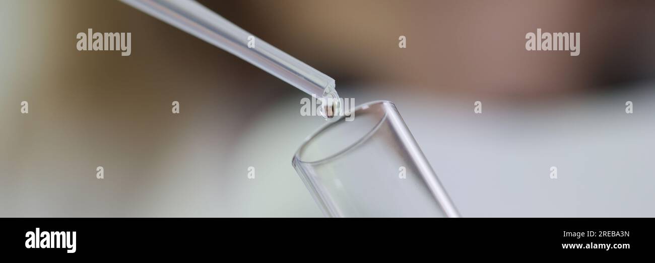 Laboratory diagnostic doctor dripping drop of liquid into test tube ...
