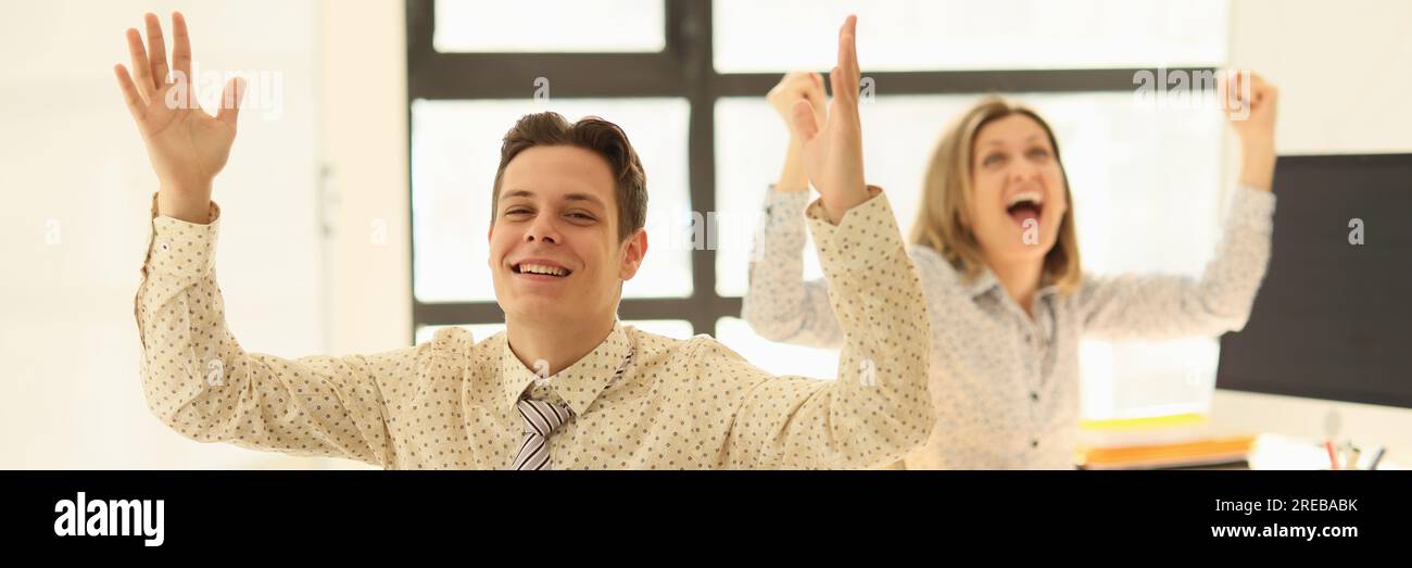 Business partners rejoicing and raising their hands up in office Stock ...