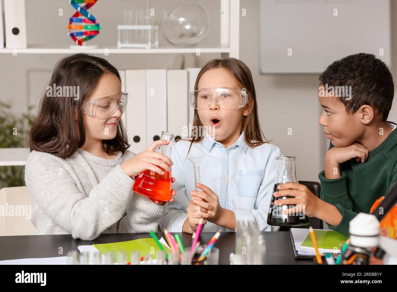 Little children conducting chemistry experiment in science classroom ...