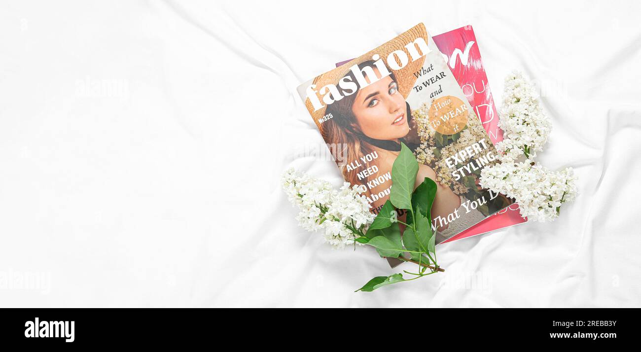 Beautiful white lilac flowers with magazines on bed, top view. Banner ...