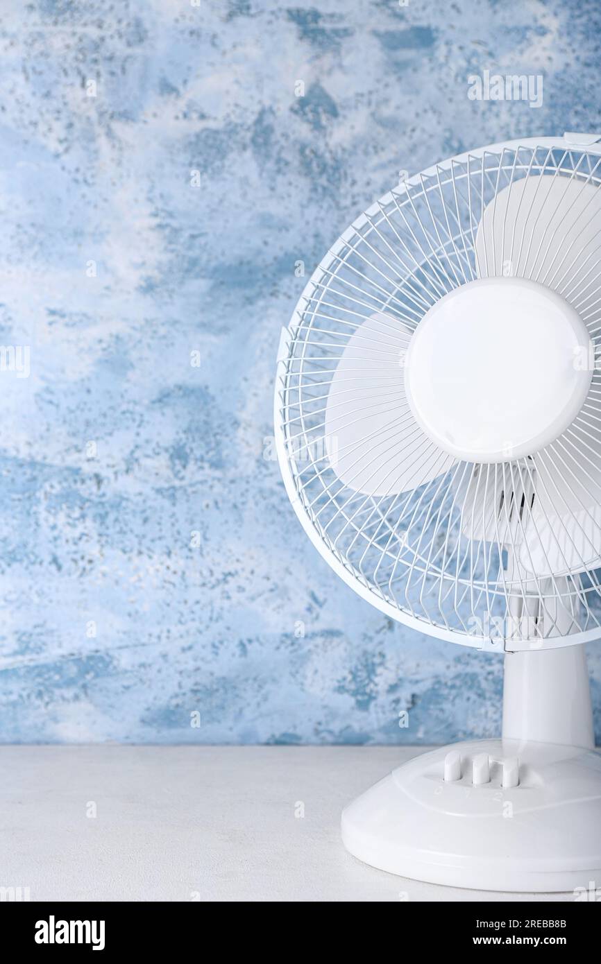 Electric fan on blue grunge background Stock Photo - Alamy
