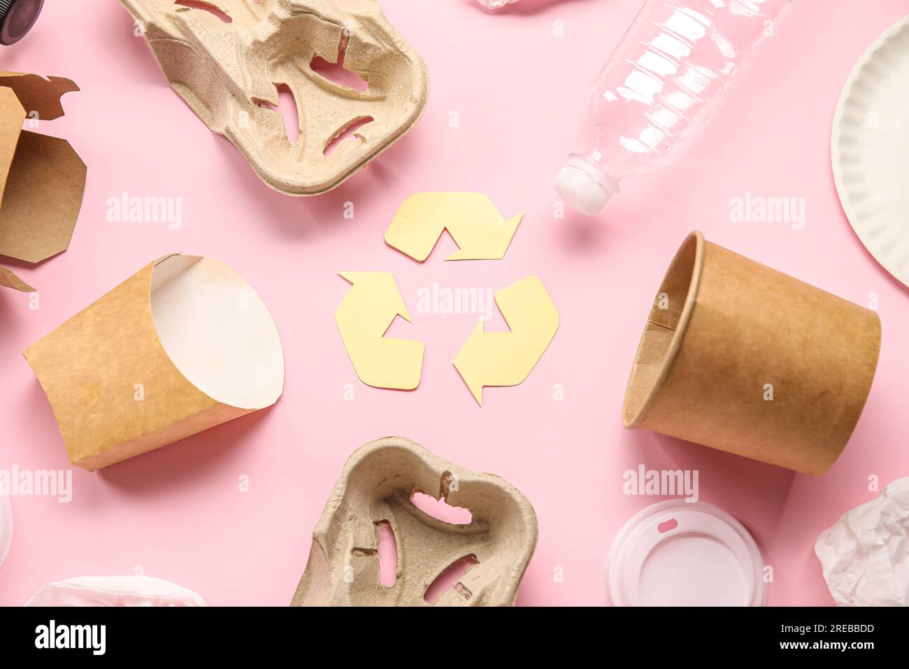 Recycling sign with garbage on pink background Stock Photo - Alamy