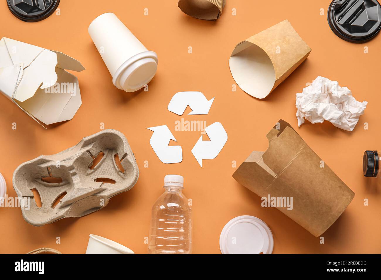 Recycling sign with garbage on orange background Stock Photo - Alamy