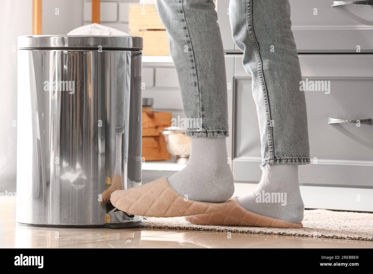Woman opening trash bin with her foot in modern kitchen Stock Photo - Alamy