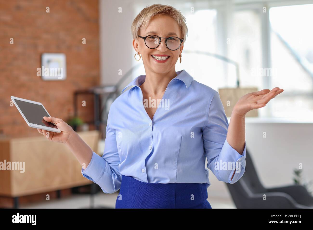 Mature psychologist with tablet computer in office Stock Photo - Alamy