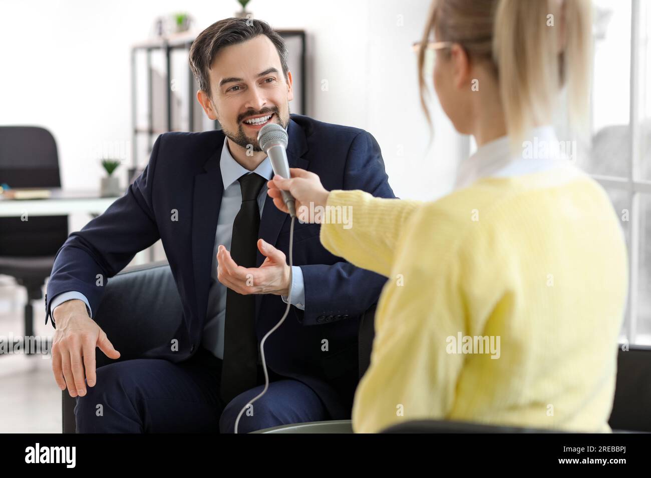 Female journalist with microphone having an interview with man in ...