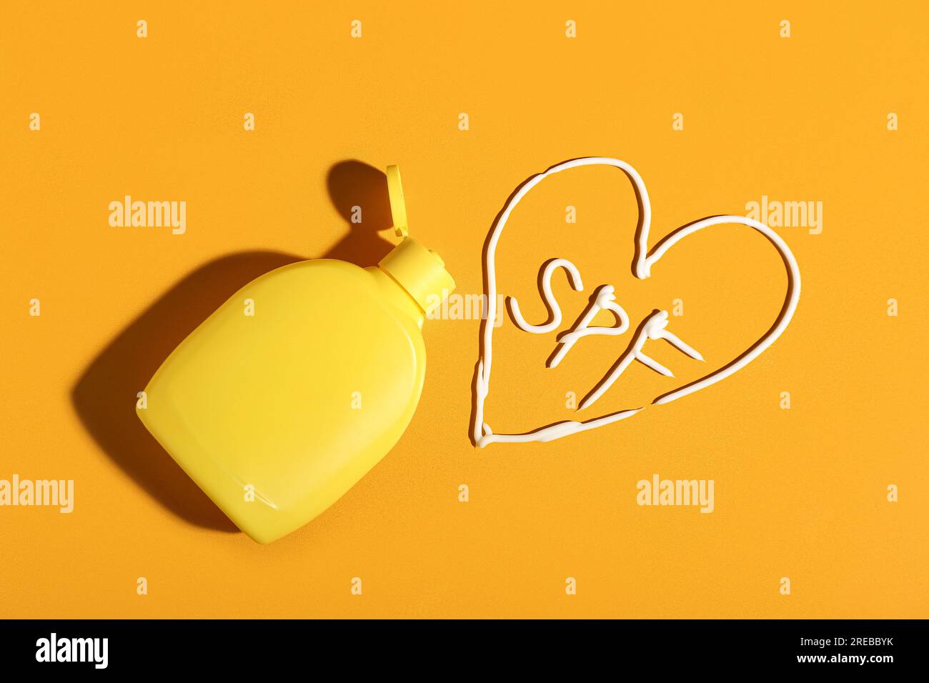 Drawing of heart and word SPF made with sunscreen cream on orange ...