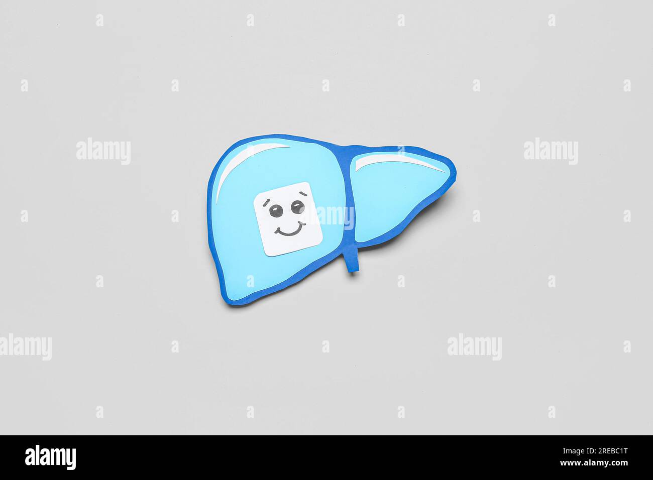 Blue paper liver with smiling face on grey background Stock Photo - Alamy