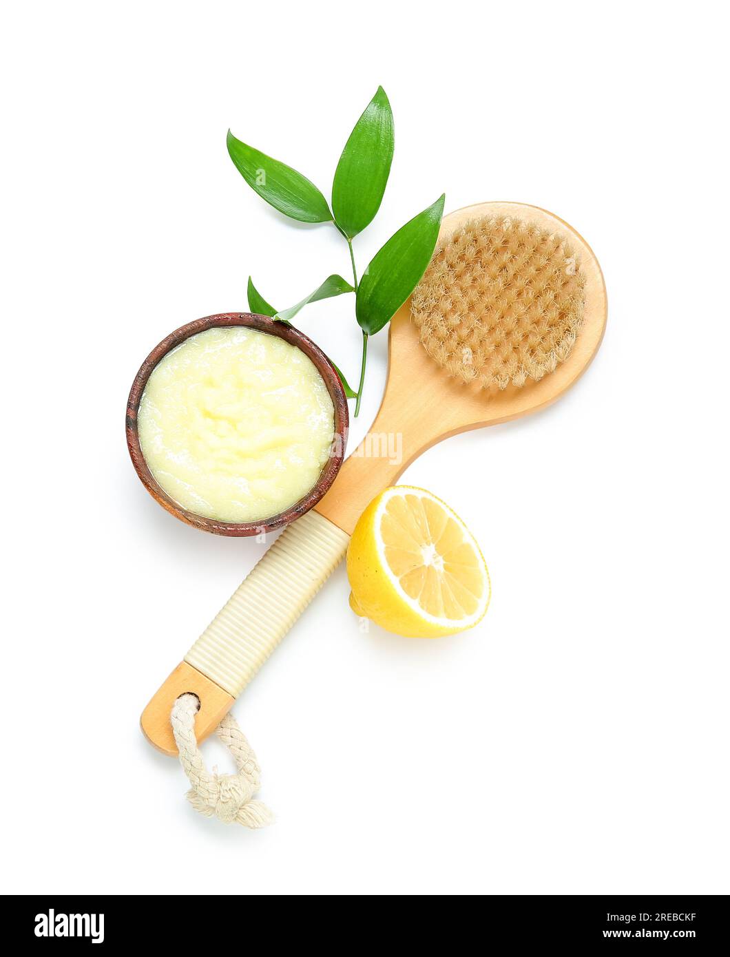 Bowl of lemon body scrub with massage brush isolated on white ...