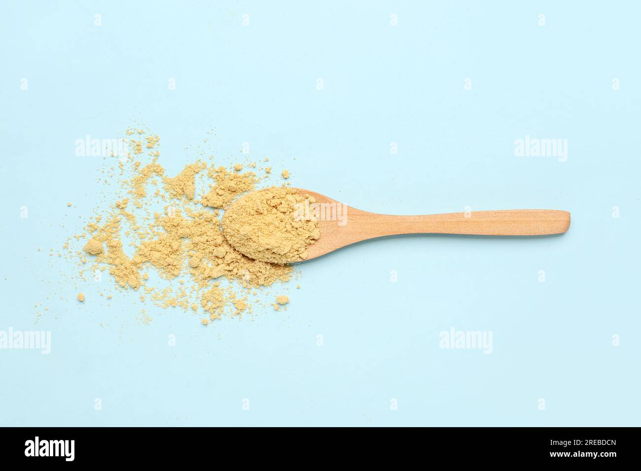 Wooden spoon with ginger powder on blue background Stock Photo - Alamy
