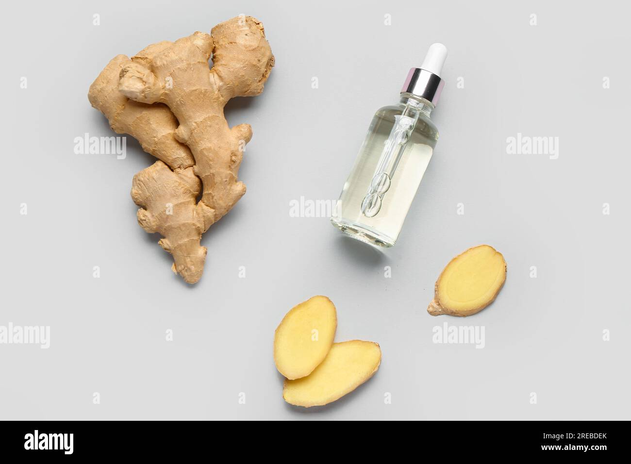 Bottle of ginger cosmetic oil on grey background Stock Photo - Alamy
