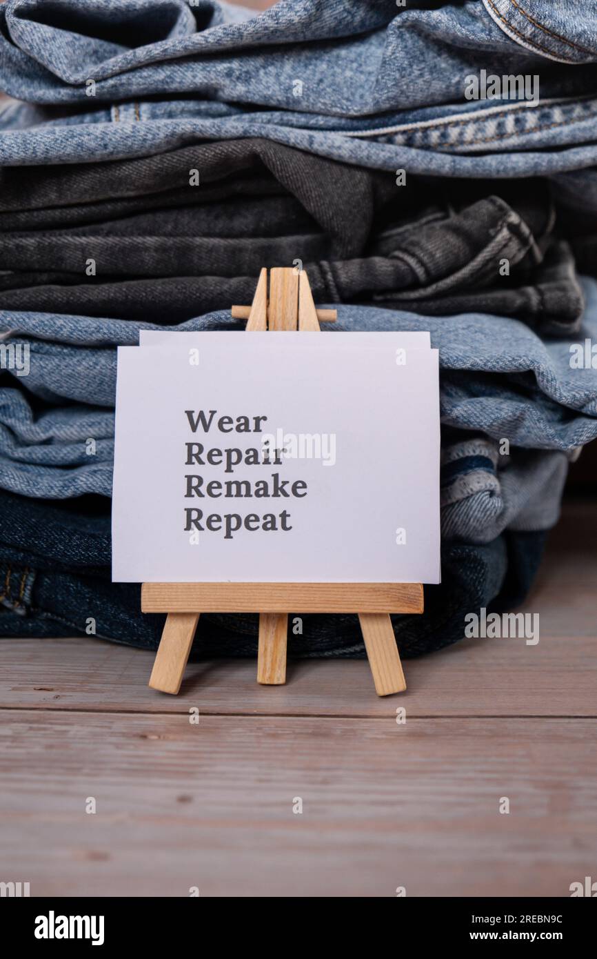 WEAR REPAIR REMAKE REPEAT text on paper note on Jeans clothes ...