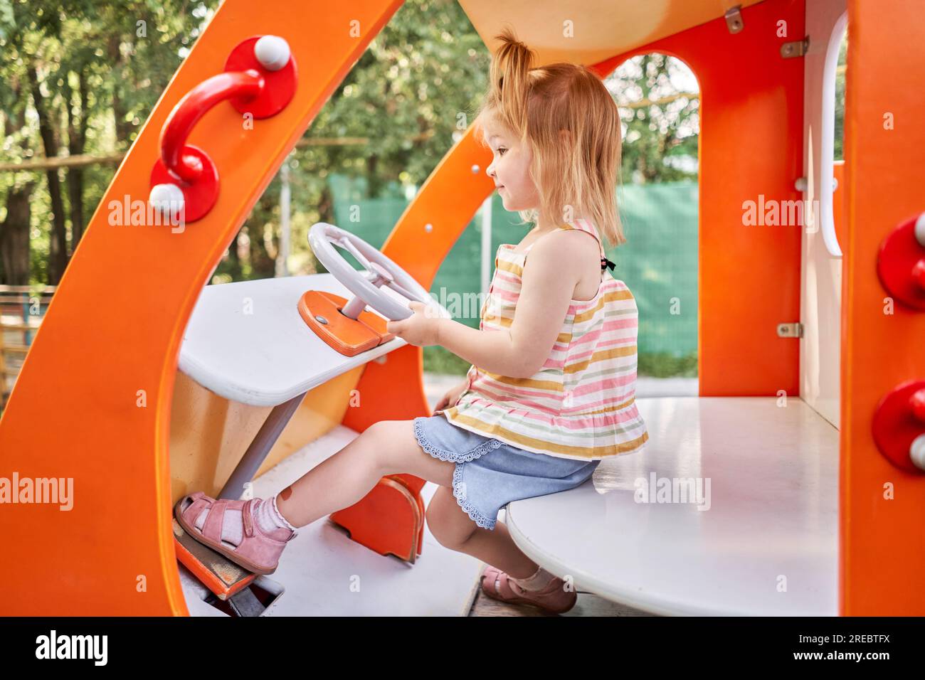 Little girl playing, she is a car driver holding steering wheel on ...