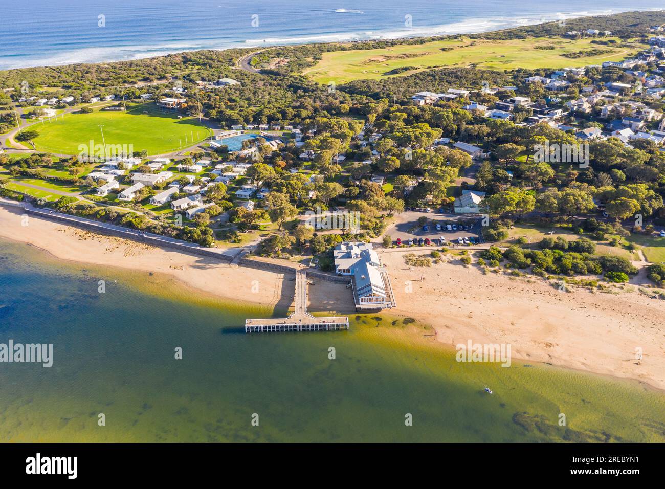 Aerial view of a t shaped jetty crossing a sandy beach to a coastal ...