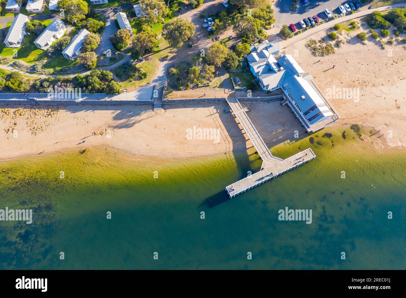 Aerial view of a t shaped jetty crossing a sandy beach to a coastal river at Barwon Heads in ...