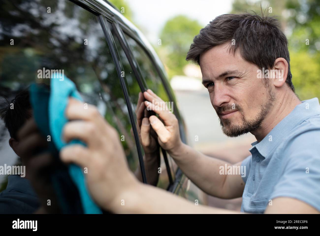 portrait of a young man cleaning his car with cloth Stock Photo - Alamy