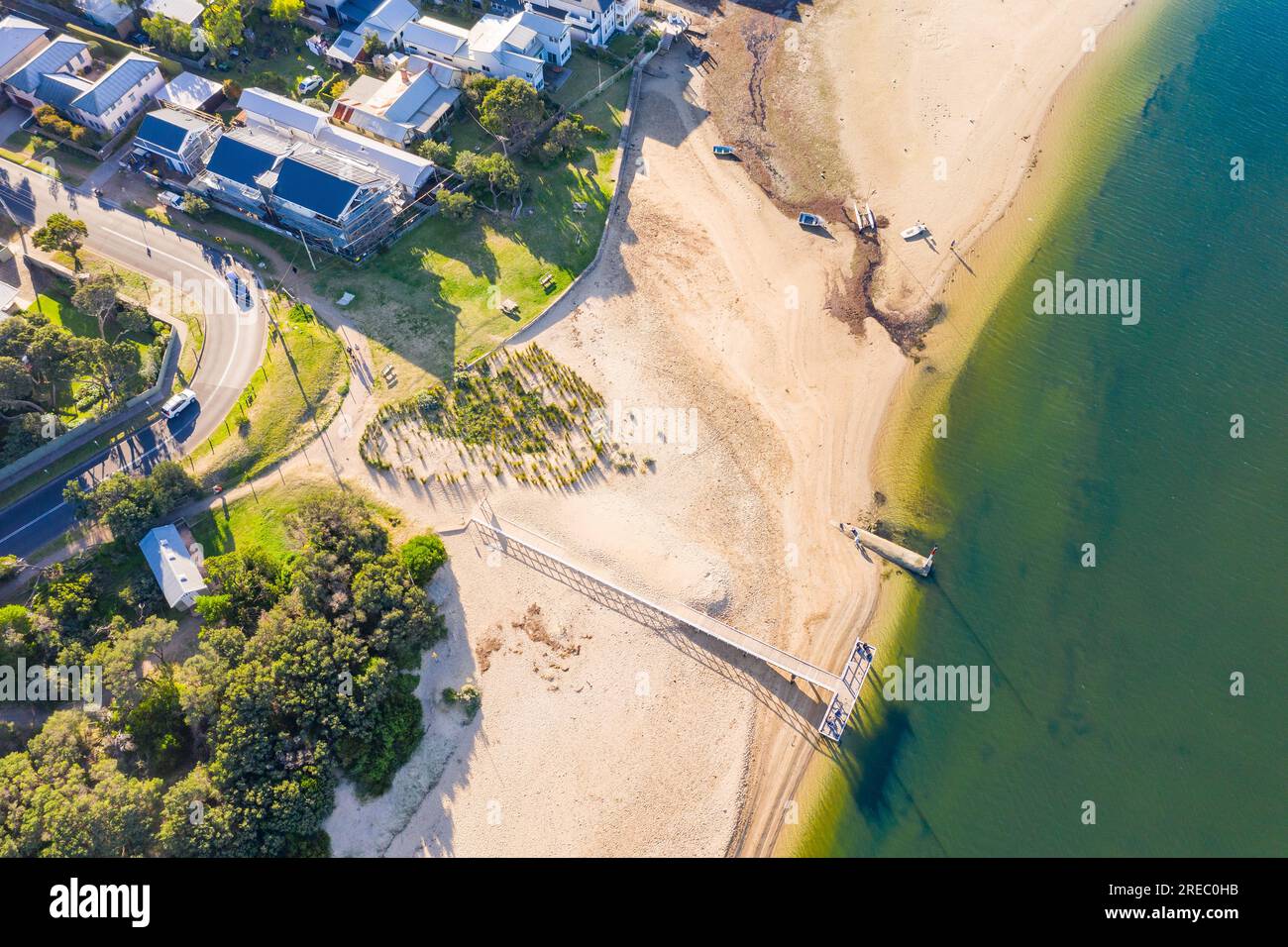 Aerial view of a t shaped jetty crossing a sandy beach over a coastal ...