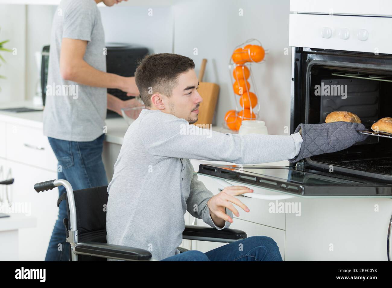 disabled young man in wheelchair opens the oven Stock Photo - Alamy