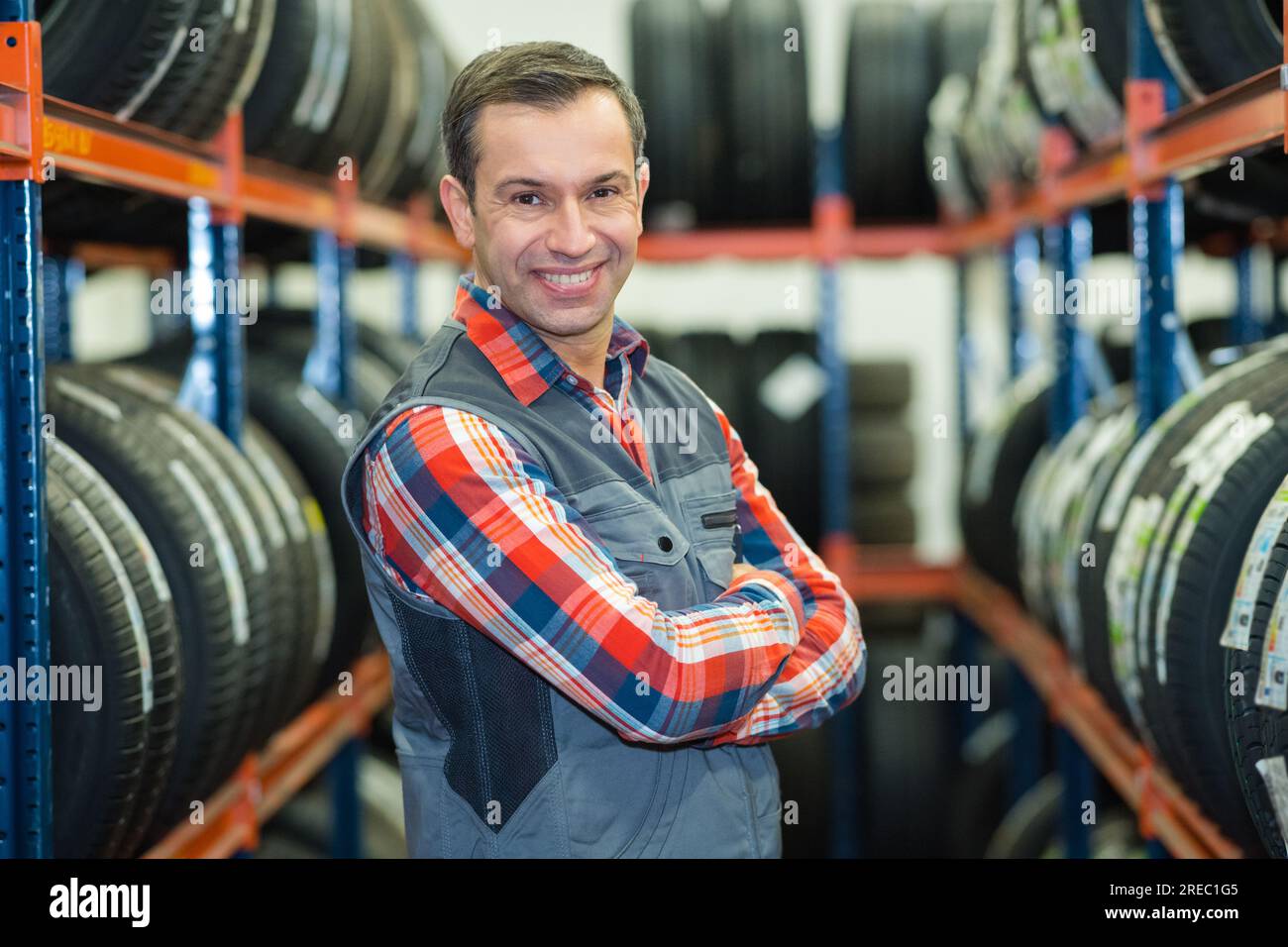 happy male worker checking tyres in a garage Stock Photo - Alamy