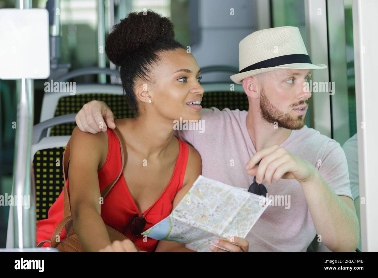 young couple holding a map while travelling on public transport Stock ...
