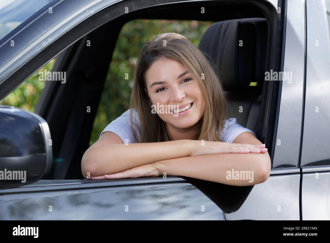 a happy female driver smiling at the camera Stock Photo - Alamy