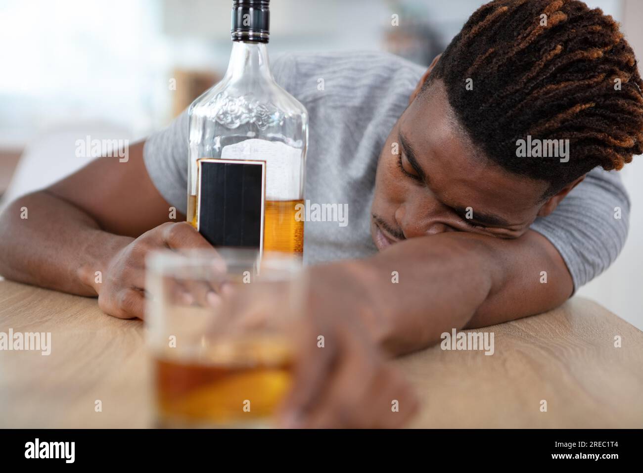 male alcoholic with glass of whiskey and bottle Stock Photo - Alamy