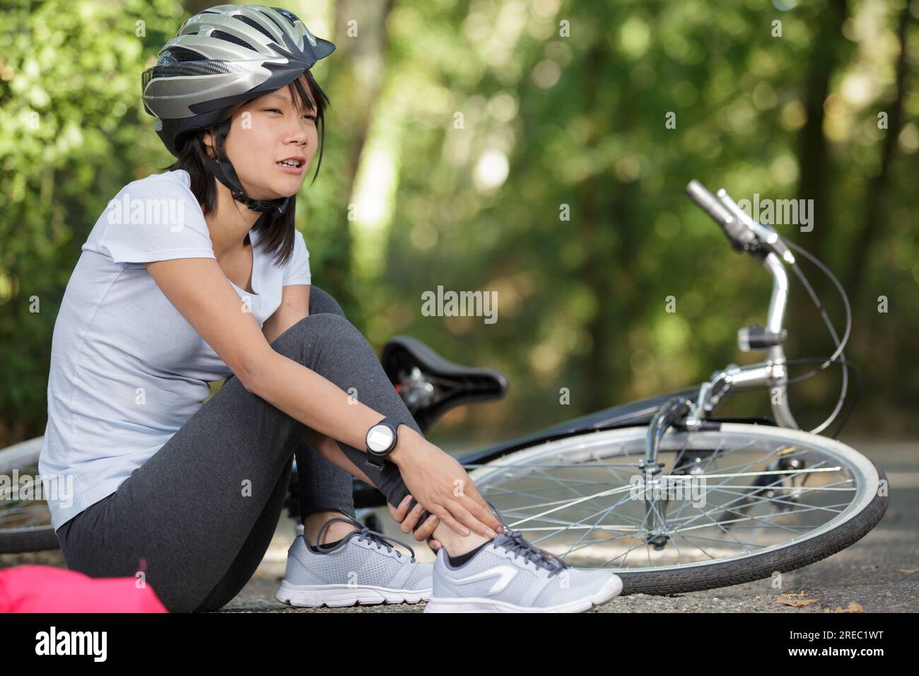 young woman hurt her leg because of bike accident Stock Photo - Alamy