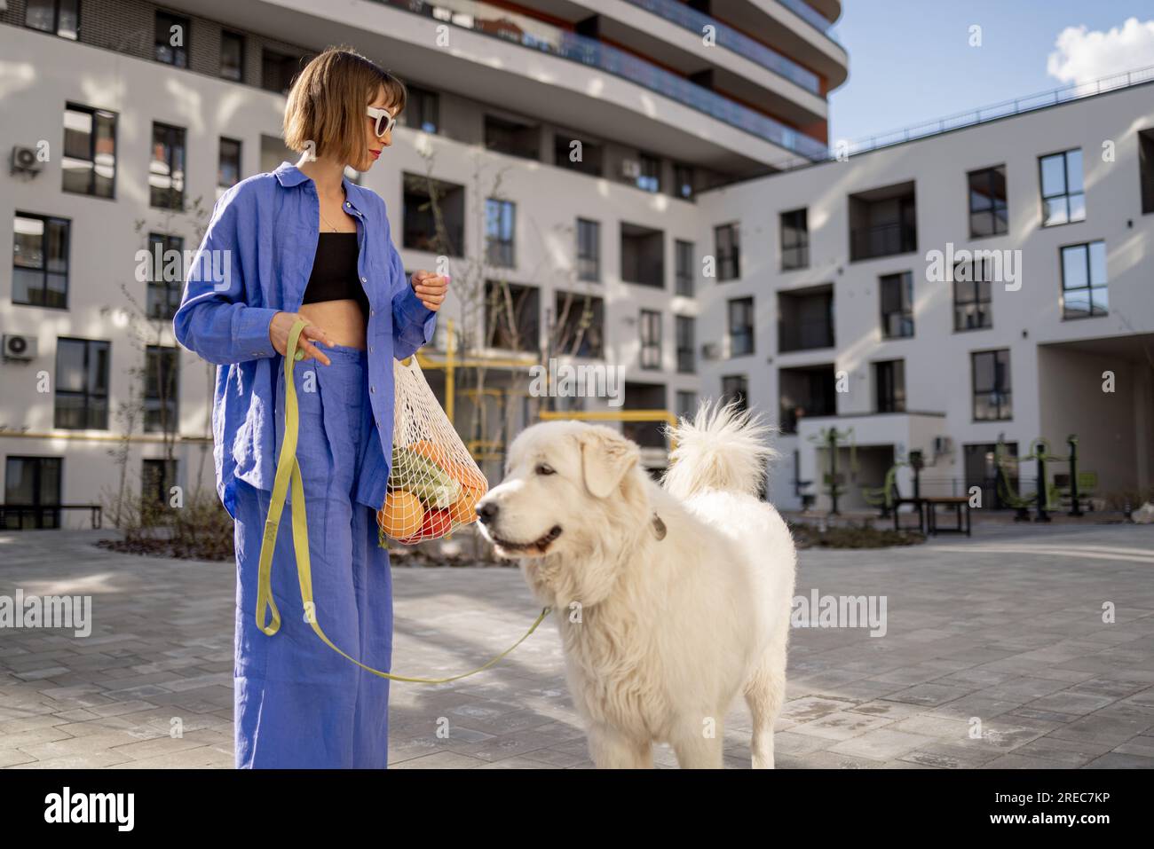 Woman carrying meshbag with fresh groceries while walking home with her ...