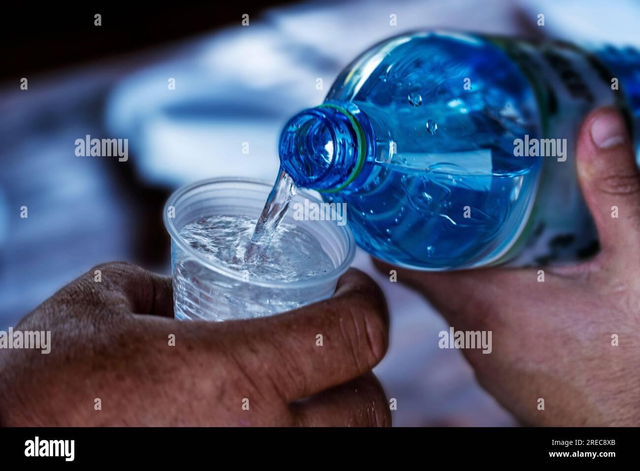 Pure water is poured from a bottle of mineral water into a clear glass of health and refreshing ...