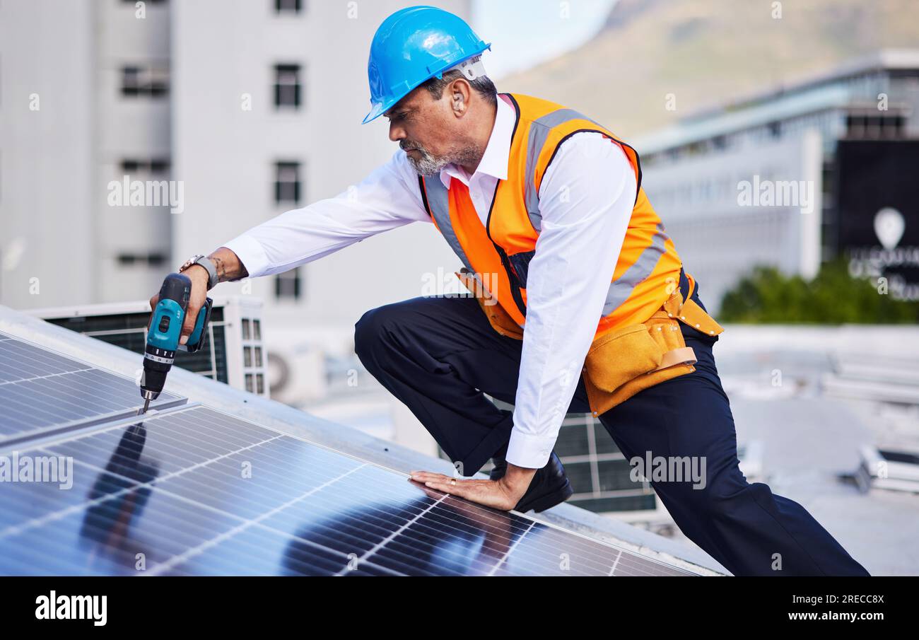 Solar panels, man and power drill for engineering, grid and building ...