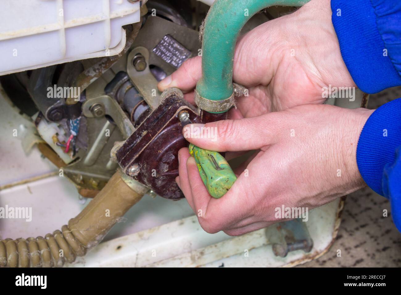 A man screwdriver with a washing machine motor Stock Photo - Alamy