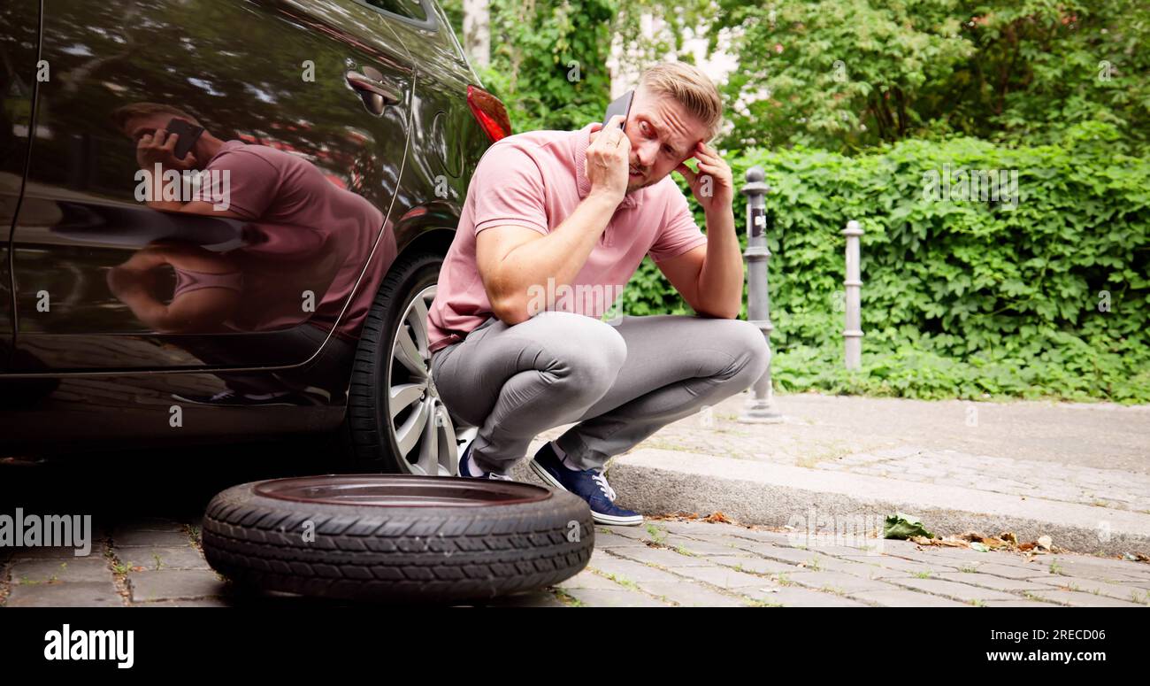 Car With Flat Tire. Man Calling On Phone Stock Photo - Alamy