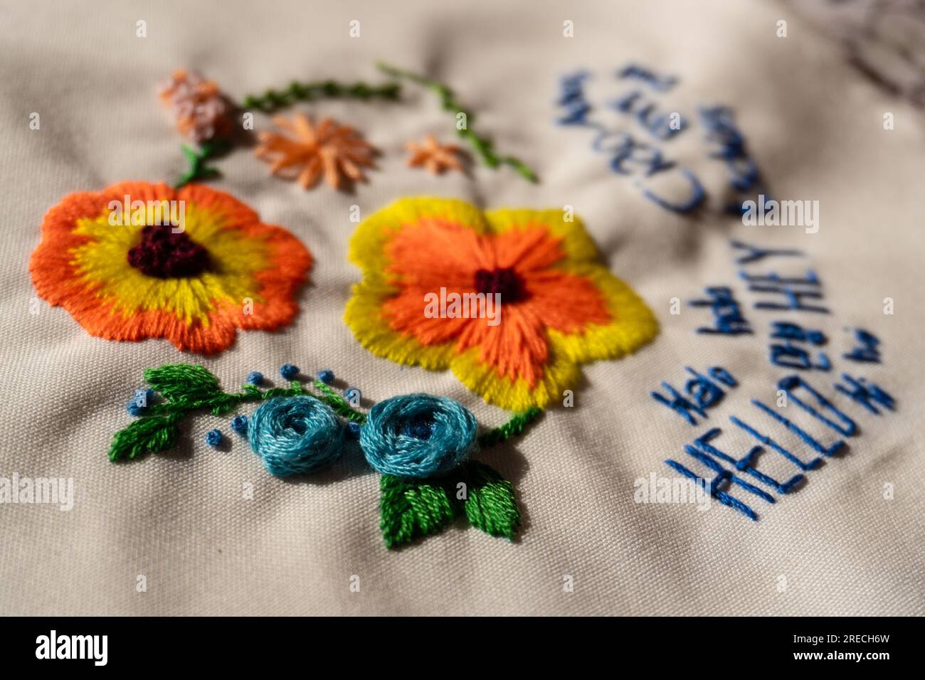A floral embroidery with letters on a white cloth (hallo and bye in ...
