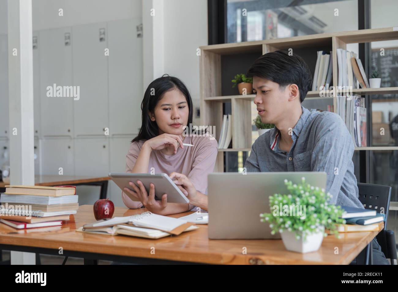 Education, teaching, learning, technology and people concept. Two Asian ...