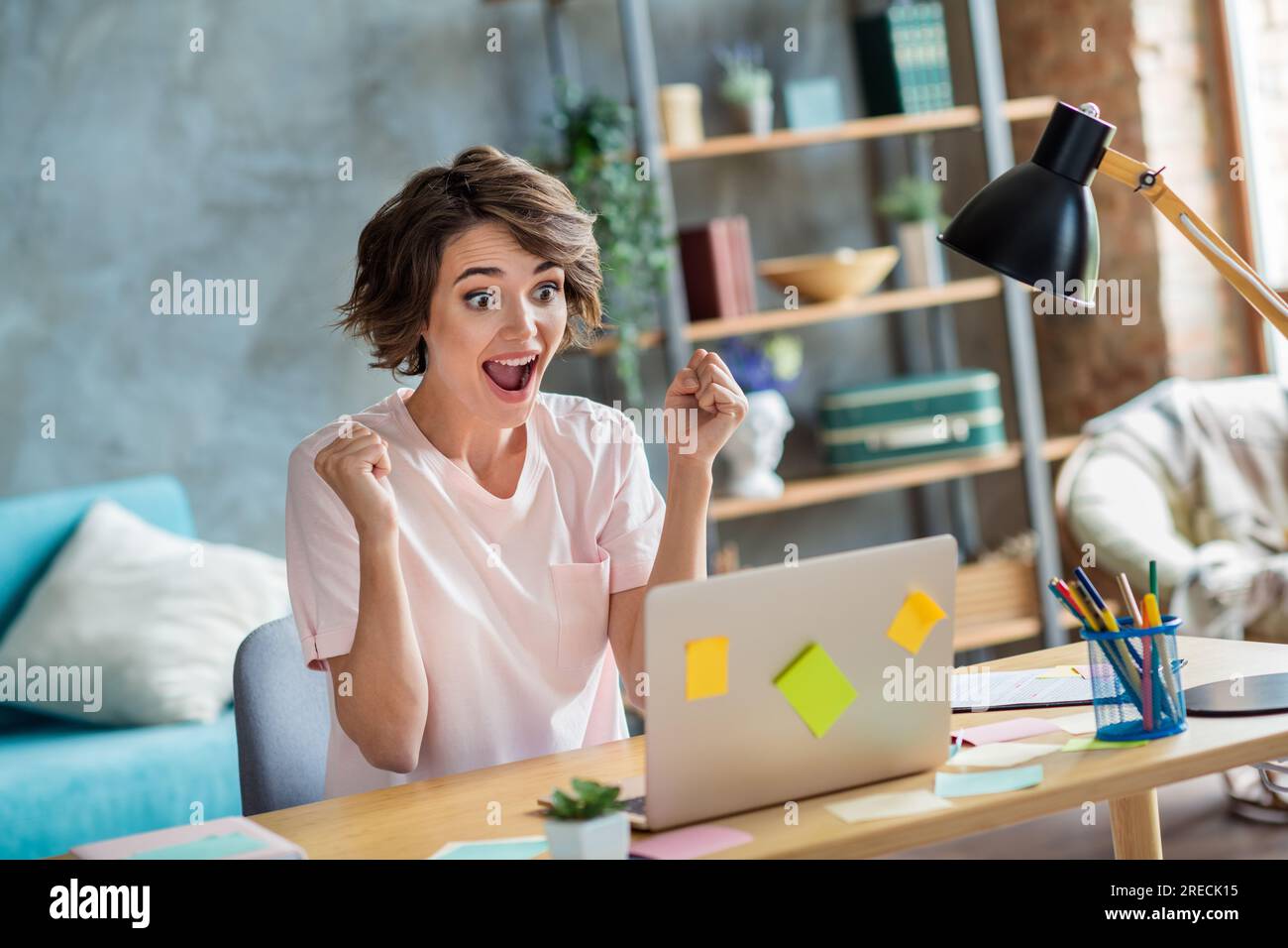 Photo of young workaholic woman bob brown hair fists up hooray screaming shocked netbook desk ...