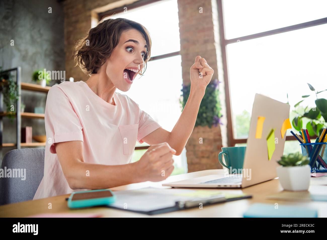 Photo of crazy young girl fists up watching netbook results she ...