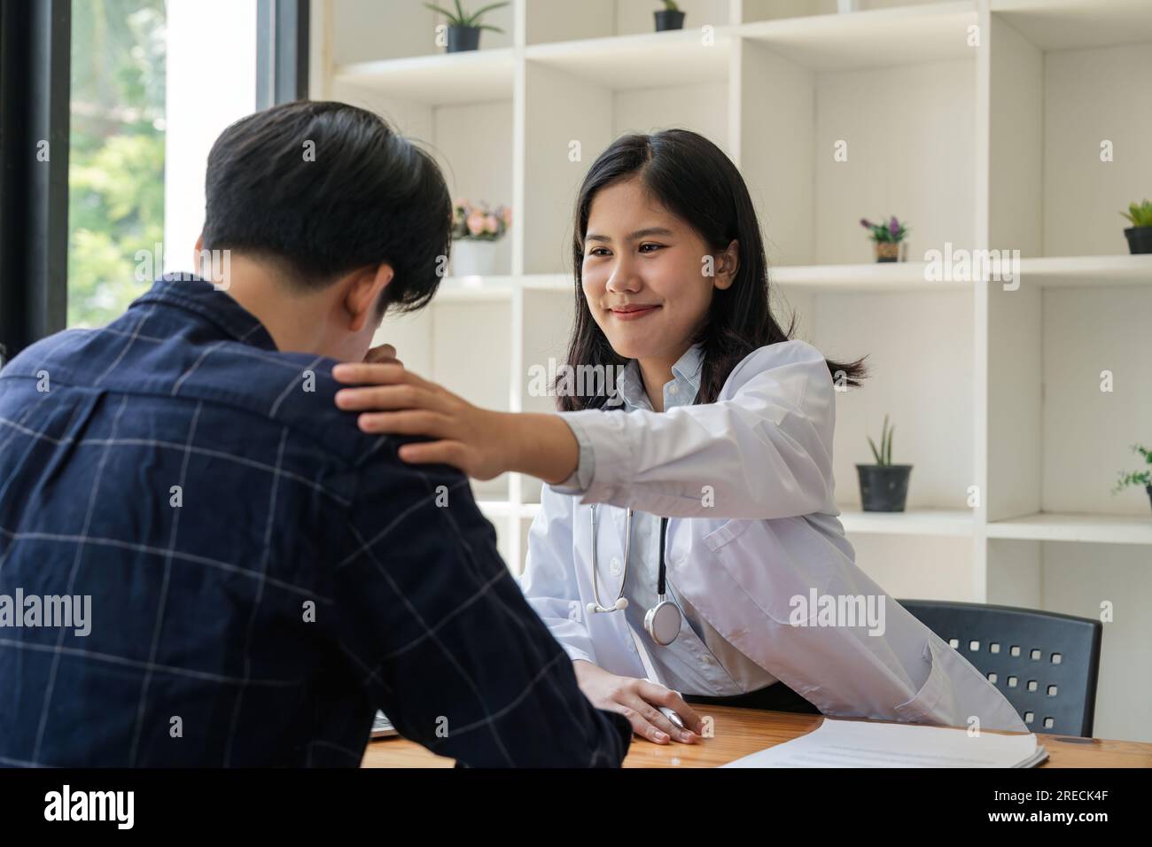 Asian female doctor giving hope and encourage to stressed man patient ...