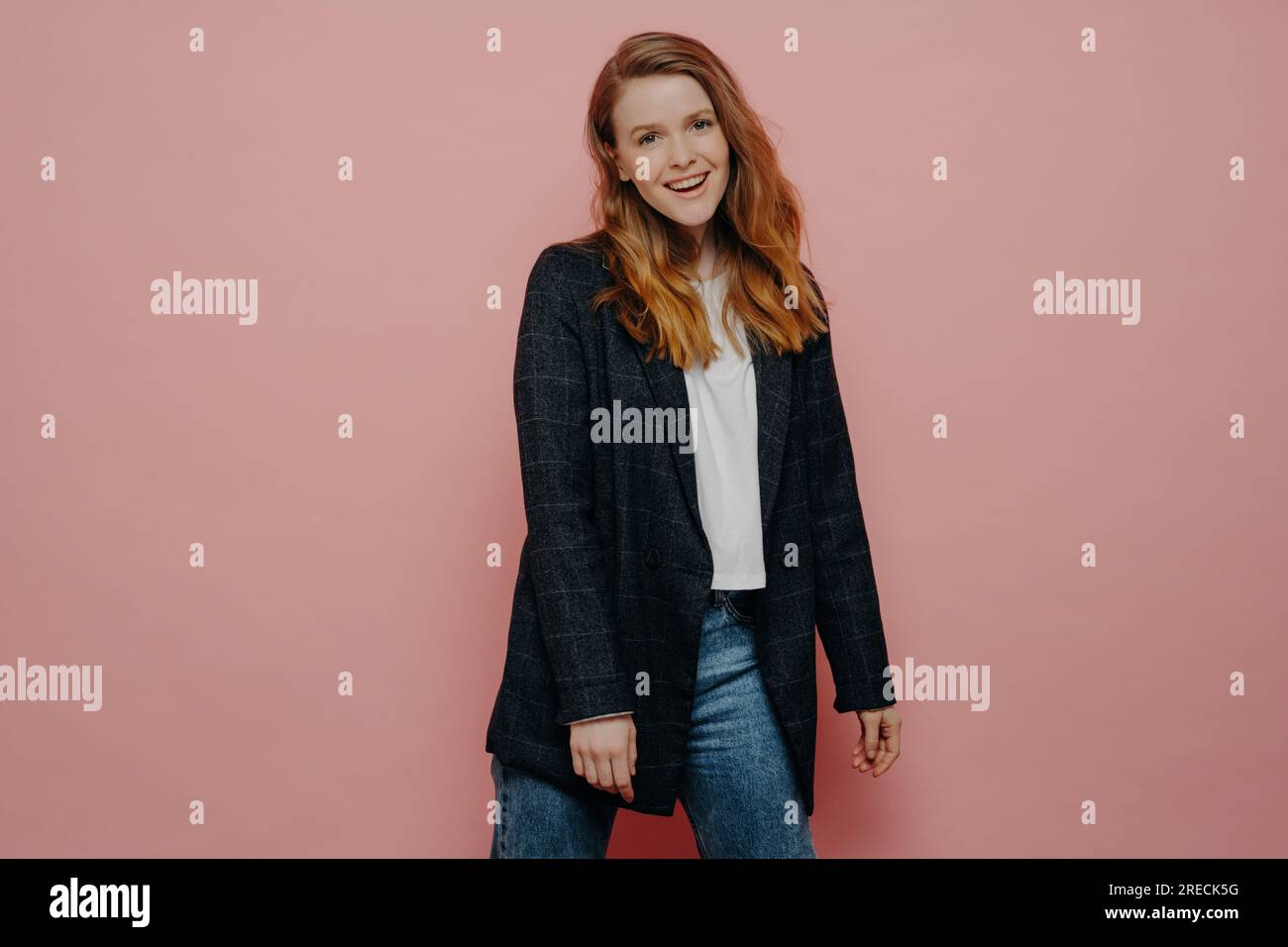 Stylish young woman in plaid blazer and jeans, posing carefree and ...