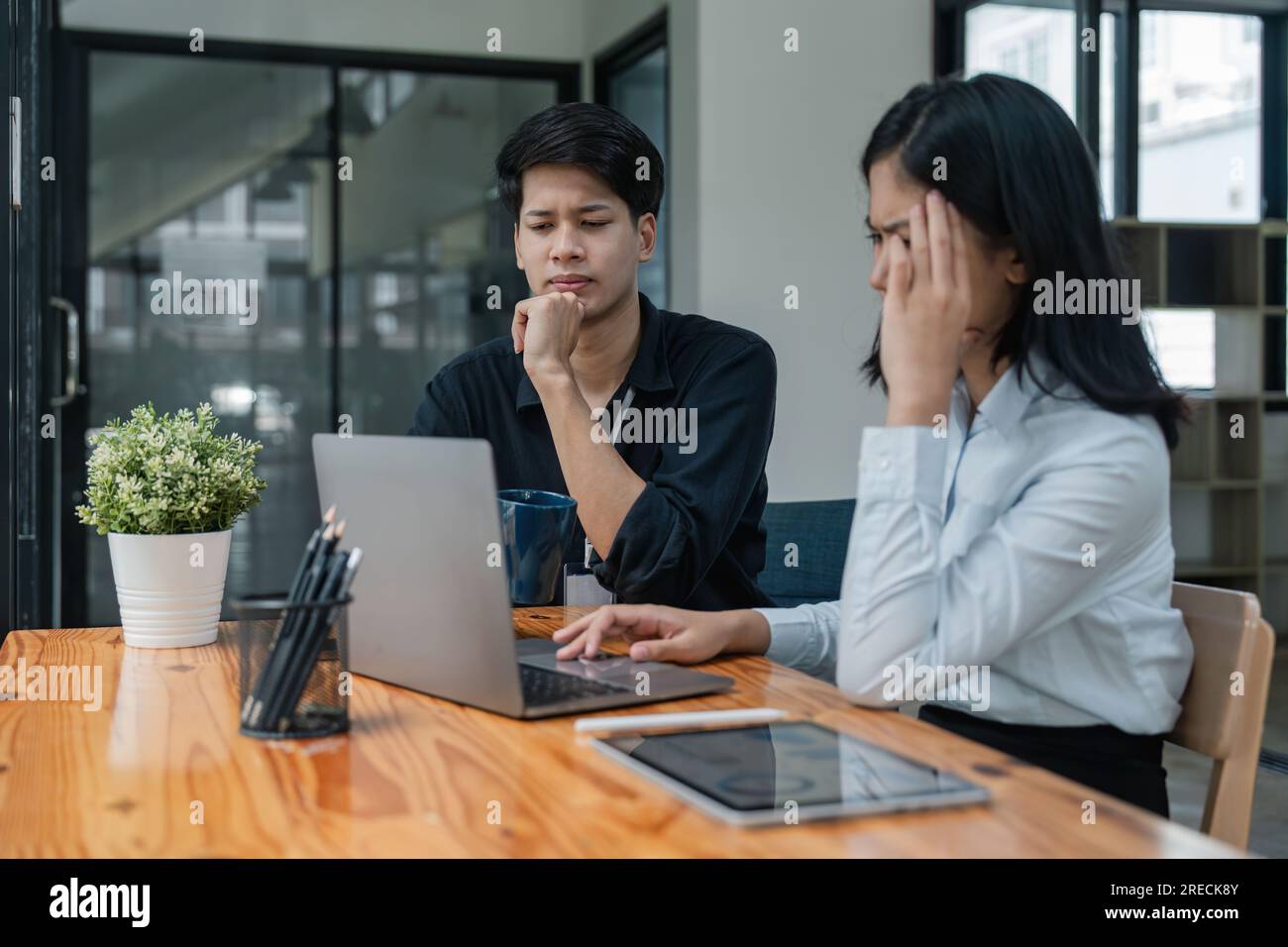 Two Asian business feeling migraine head strain. Overworked ...