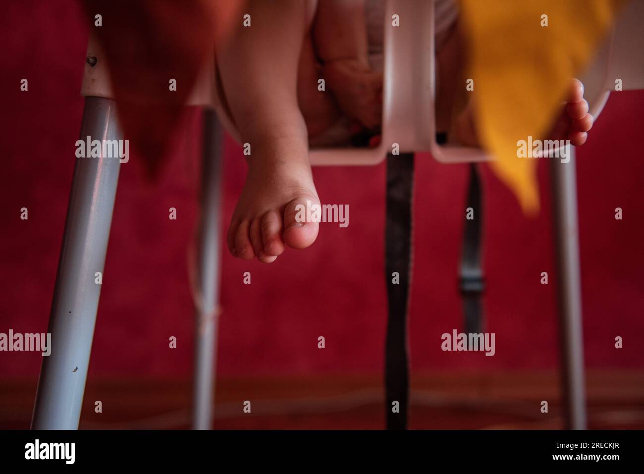 Faceless portrait of baby sitting in feeding chair, festively decorated ...