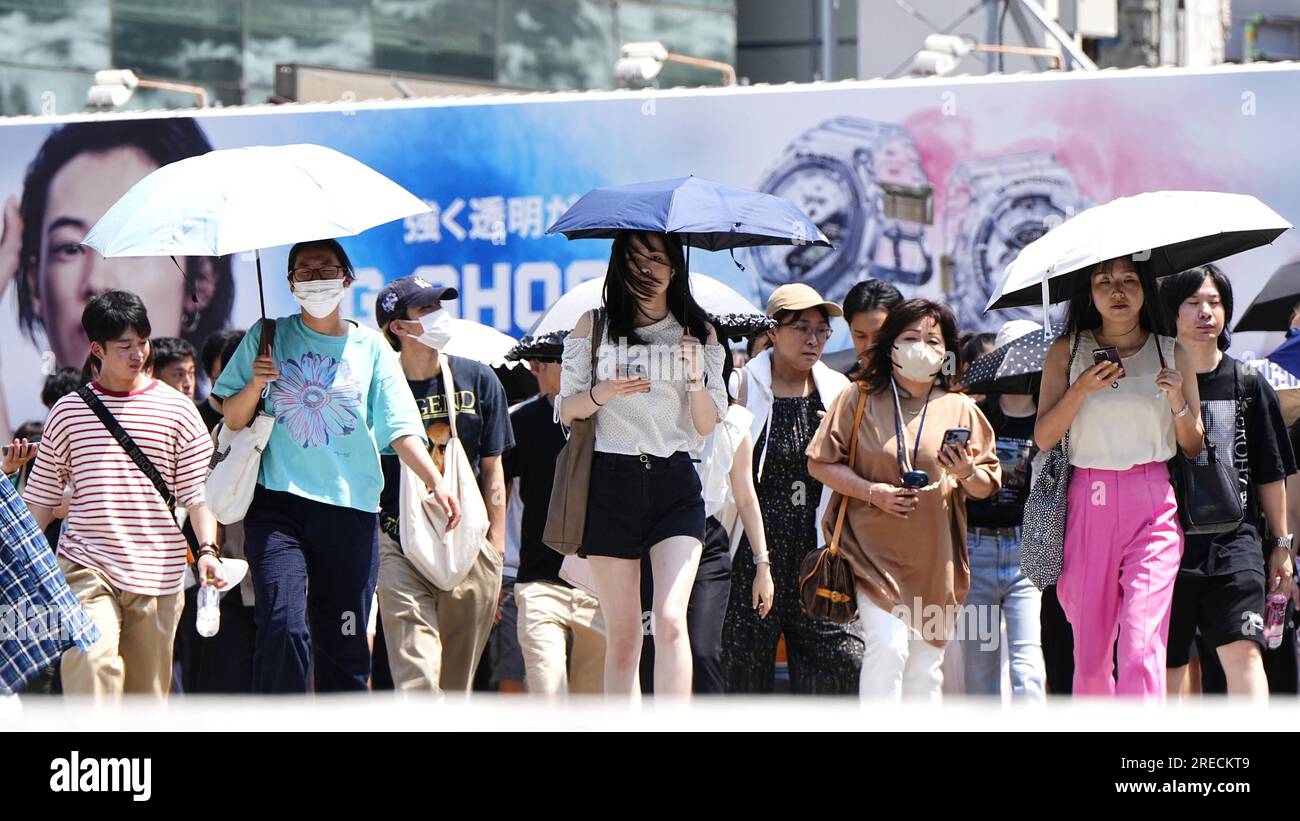 People walk with parasols on a sweltering hot day in Tokyo's Shibuya ...