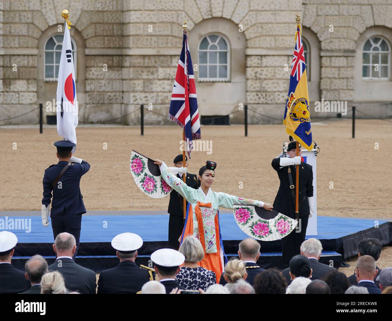 Flag bearers stand as a dancer performs a traditional Korean fan dance ...
