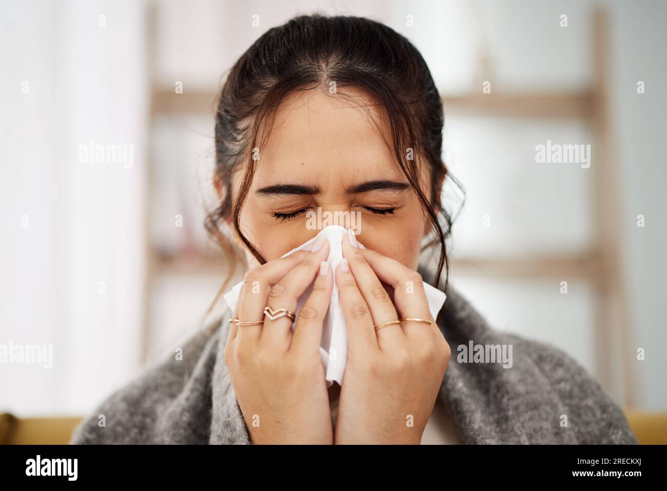 Tissue, nose and sick woman sneezing in living room with allergy, cold ...