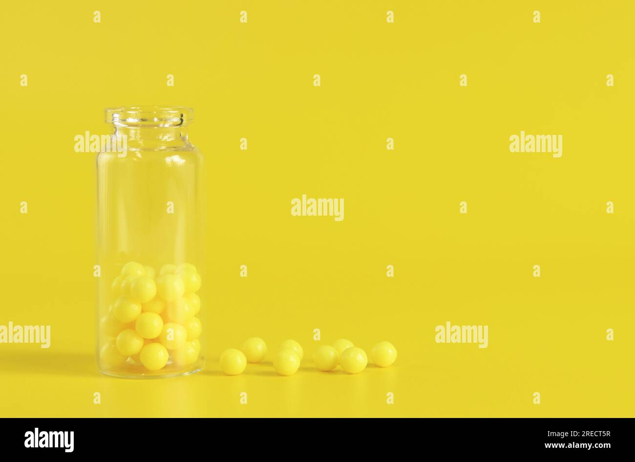 Yellow tablets in a glass bottle, ascorbic acid. Vitamins C on a yellow ...