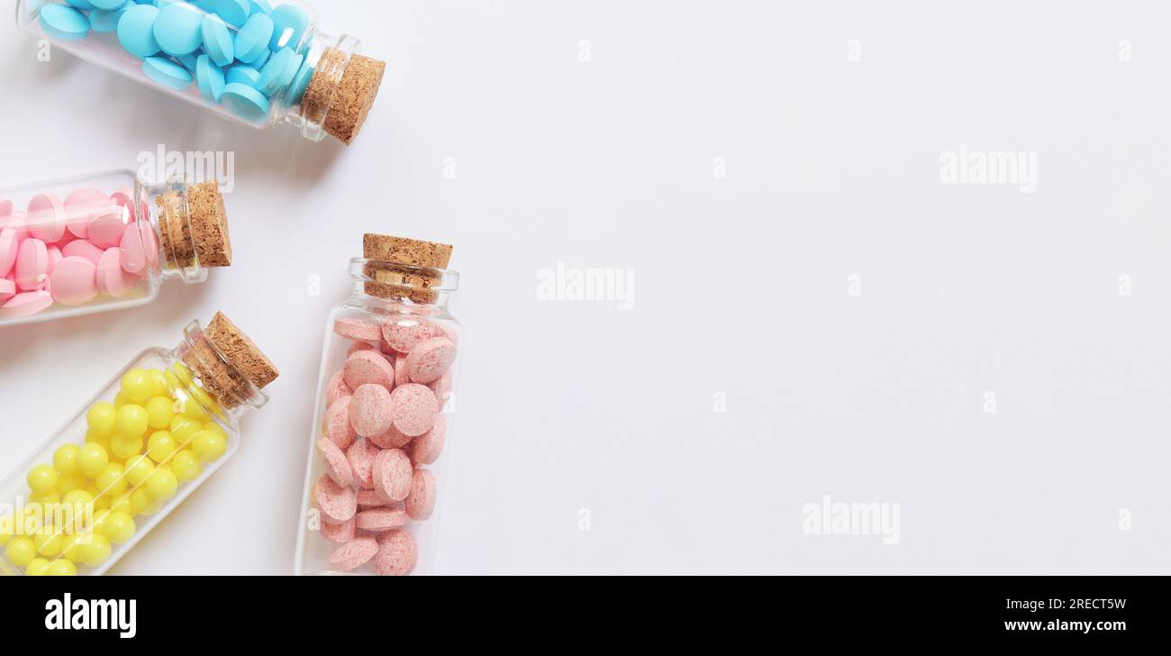Vitamins of different colors in glass bottles on a white background ...