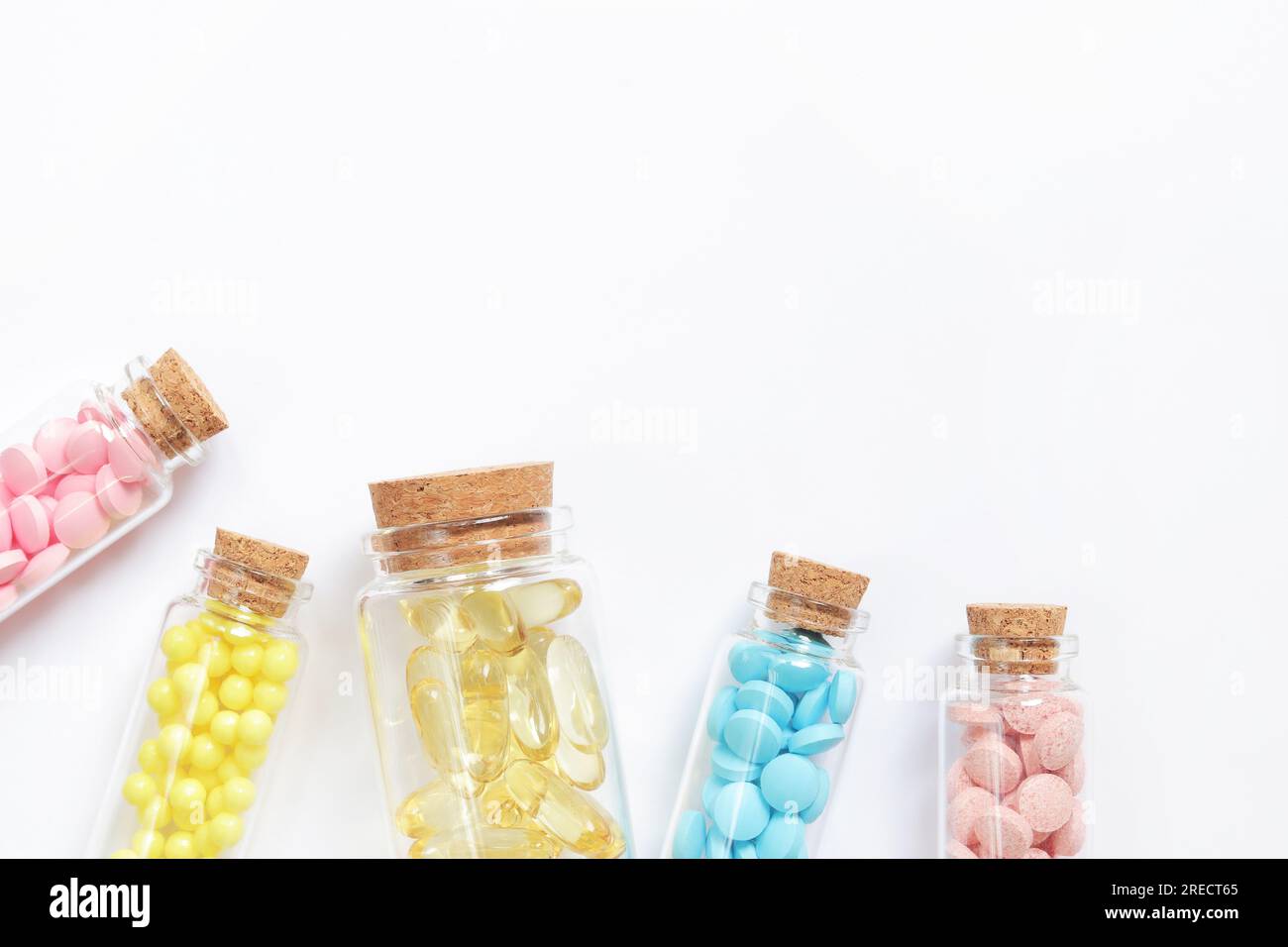 Vitamins of different colors in glass bottles on a white background ...