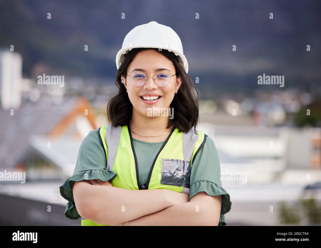 Engineering, crossed arms and portrait of a female construction worker on a building rooftop ...